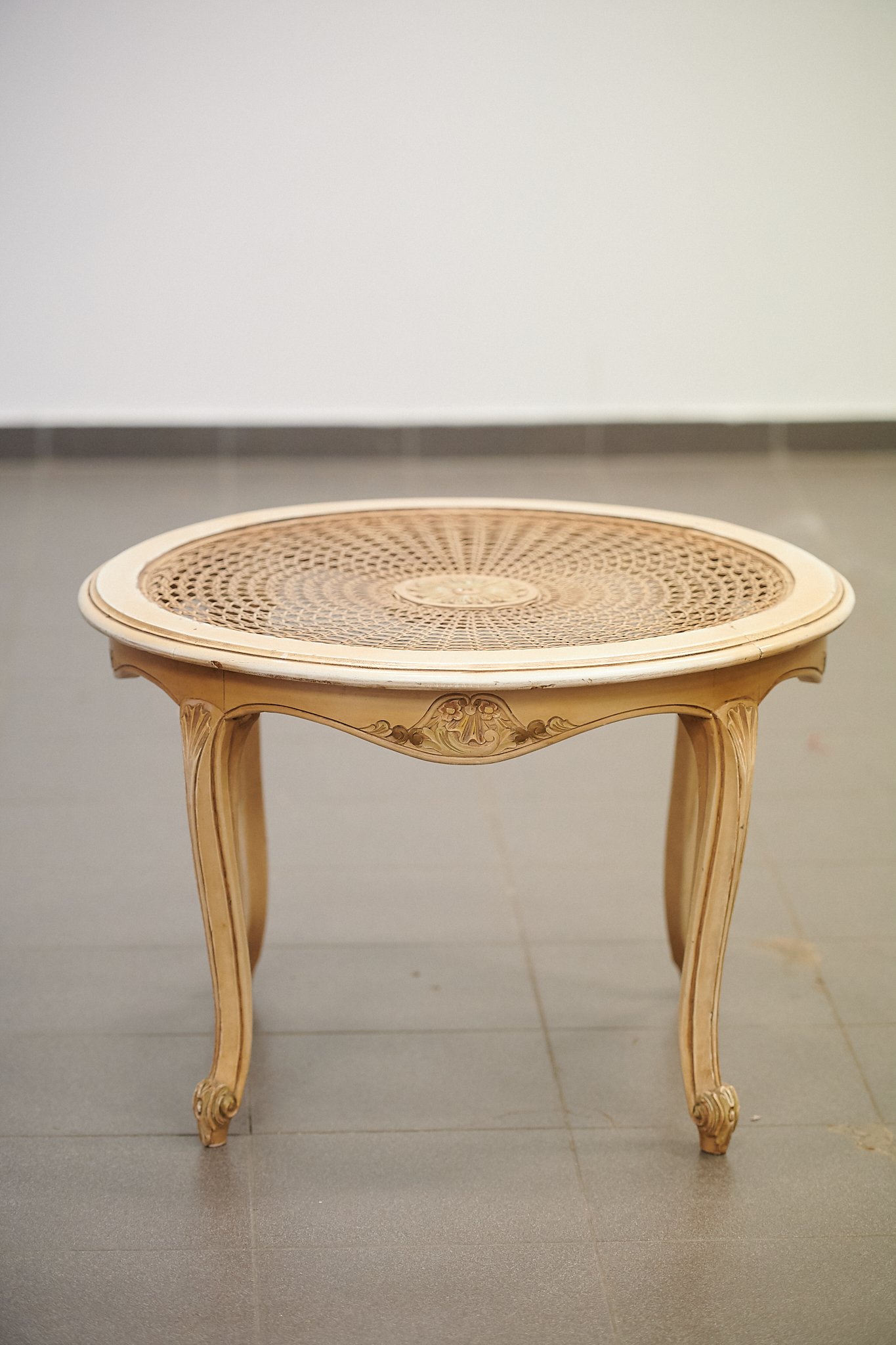 Krāsota koka galds ar rotangas pinumu antikvariāta salonā Viss Antīkais